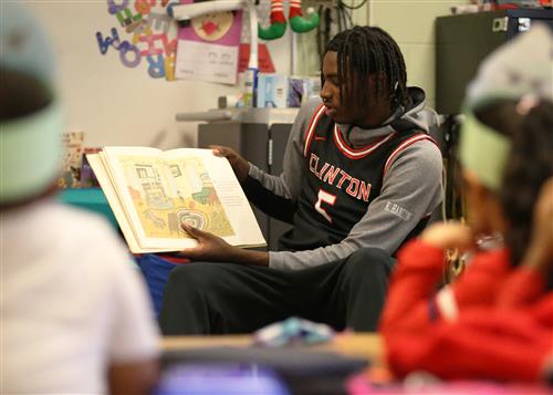 Arrows basketball team reads to elementary students - The Clinton Courier